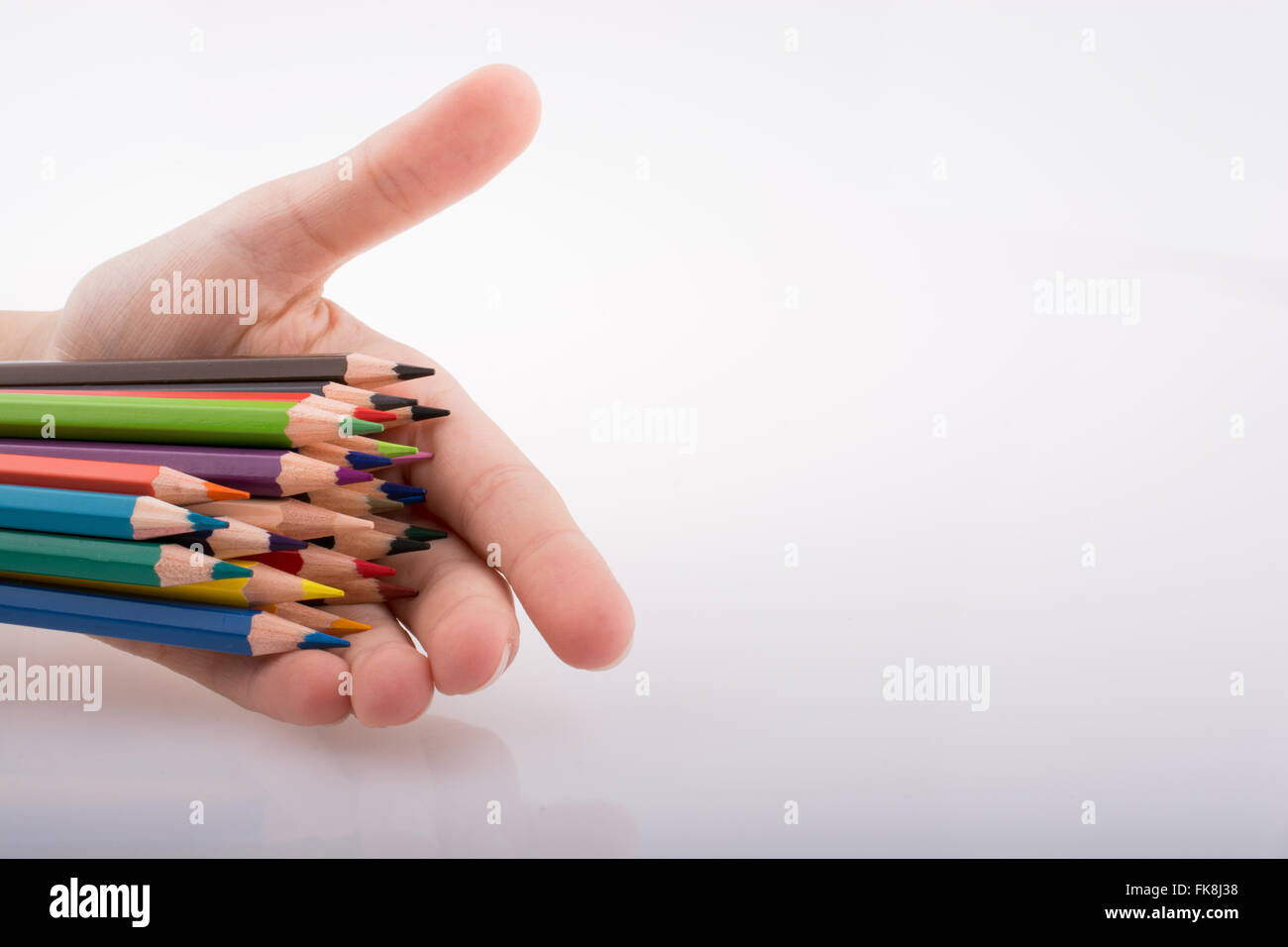 Hand holding color pencils on a white background Stock Photo - Alamy