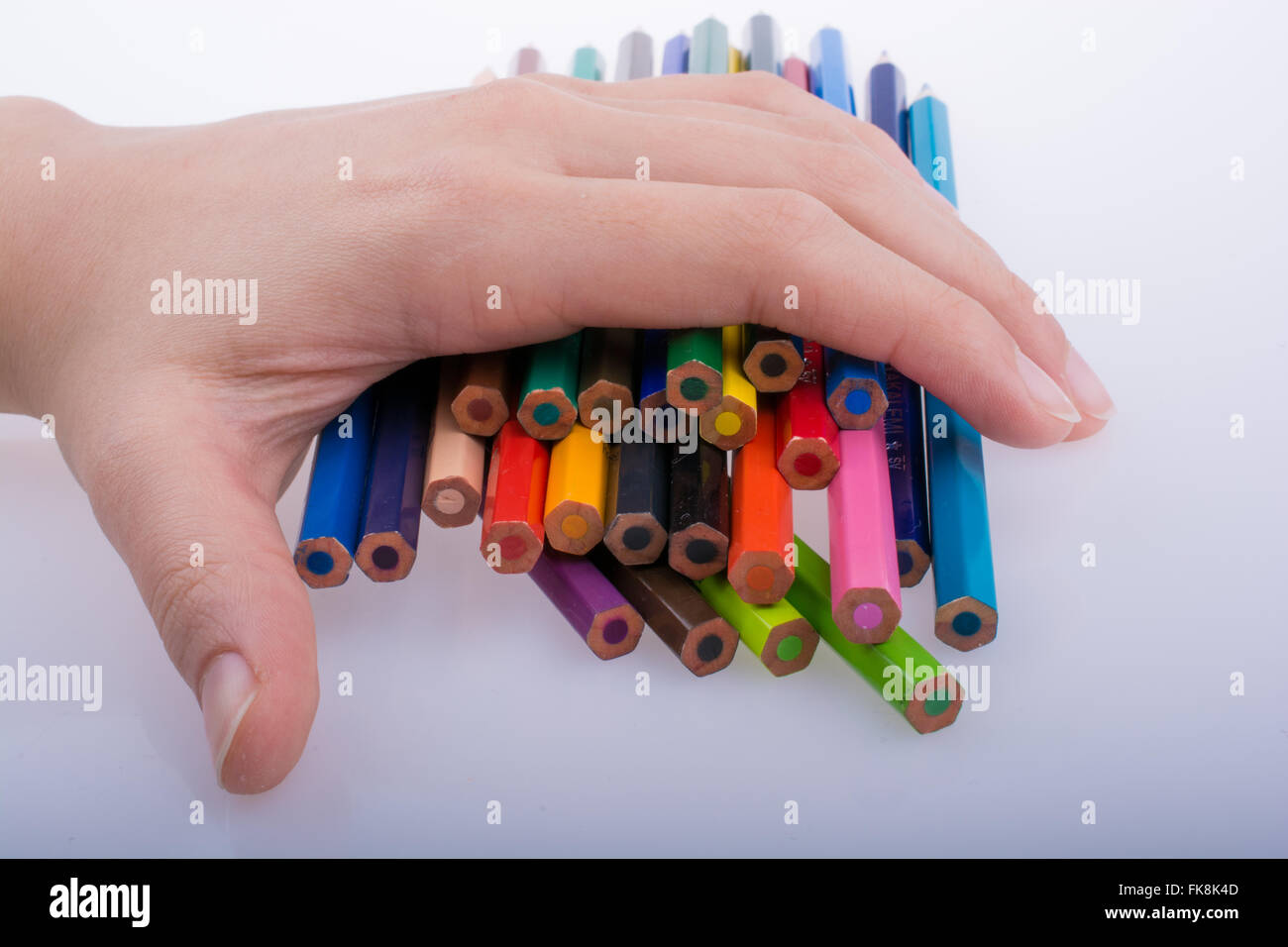Hand holding color pencils on a white background Stock Photo - Alamy
