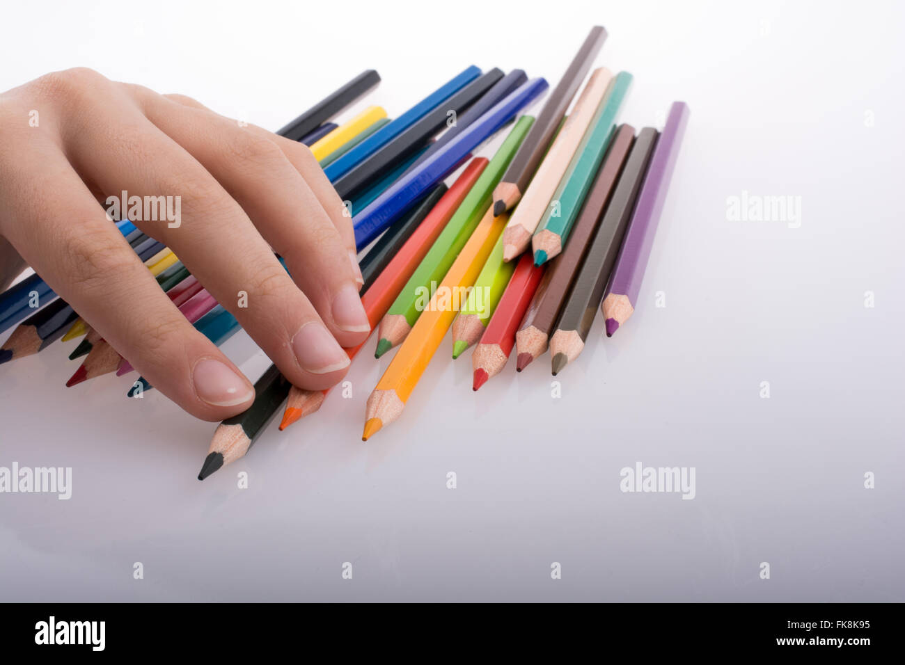 Hand holding color pencils on a white background Stock Photo - Alamy