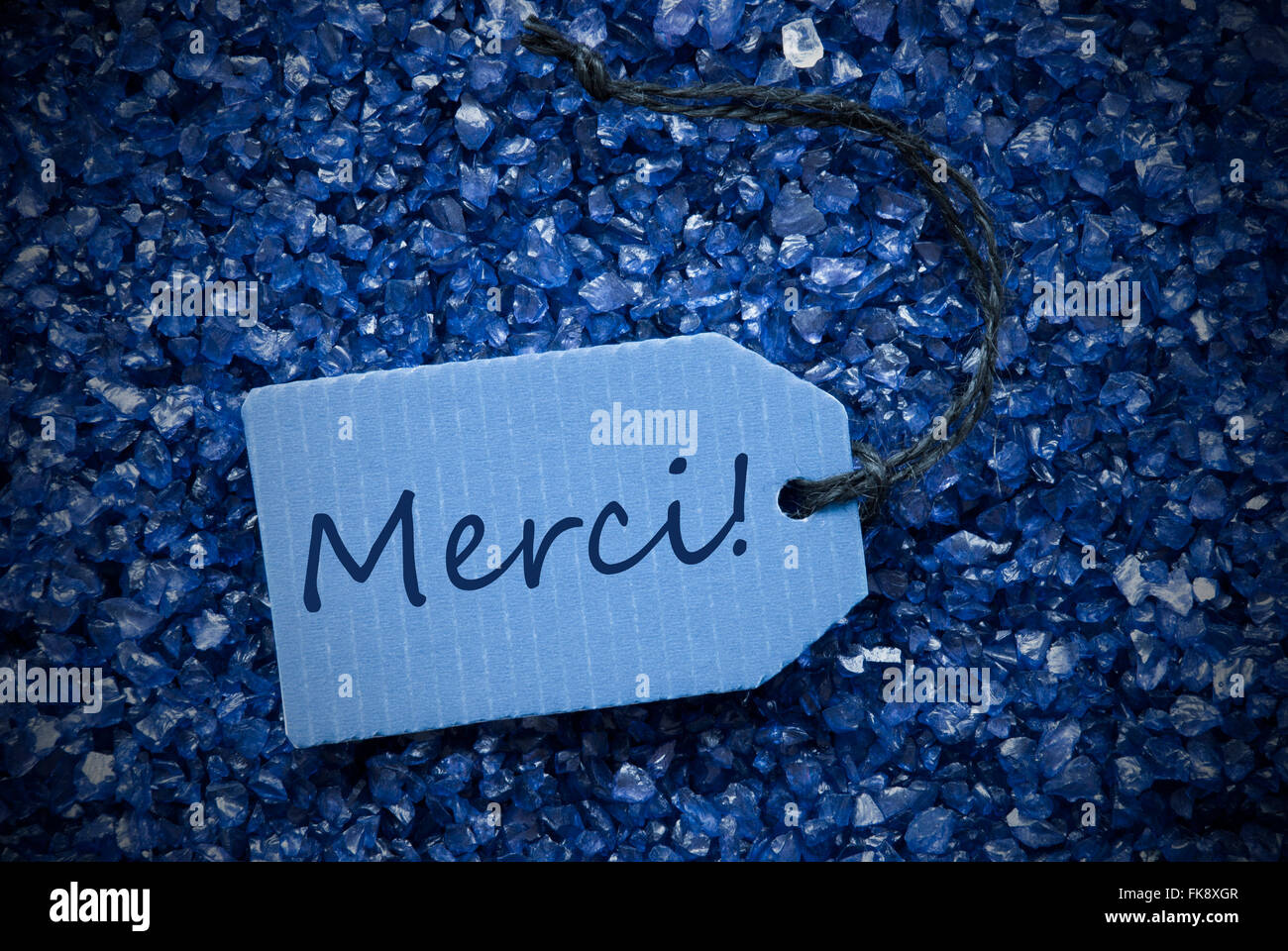 Purple Stones With Label Merci Means Thank You Stock Photo - Alamy