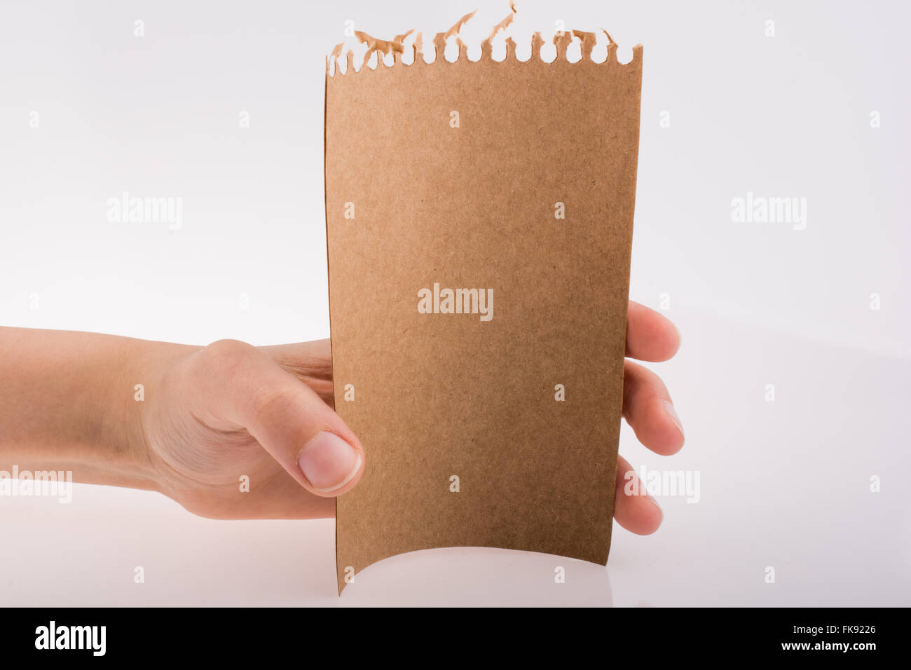 Hand holding a sheet of paper on a white background Stock Photo - Alamy