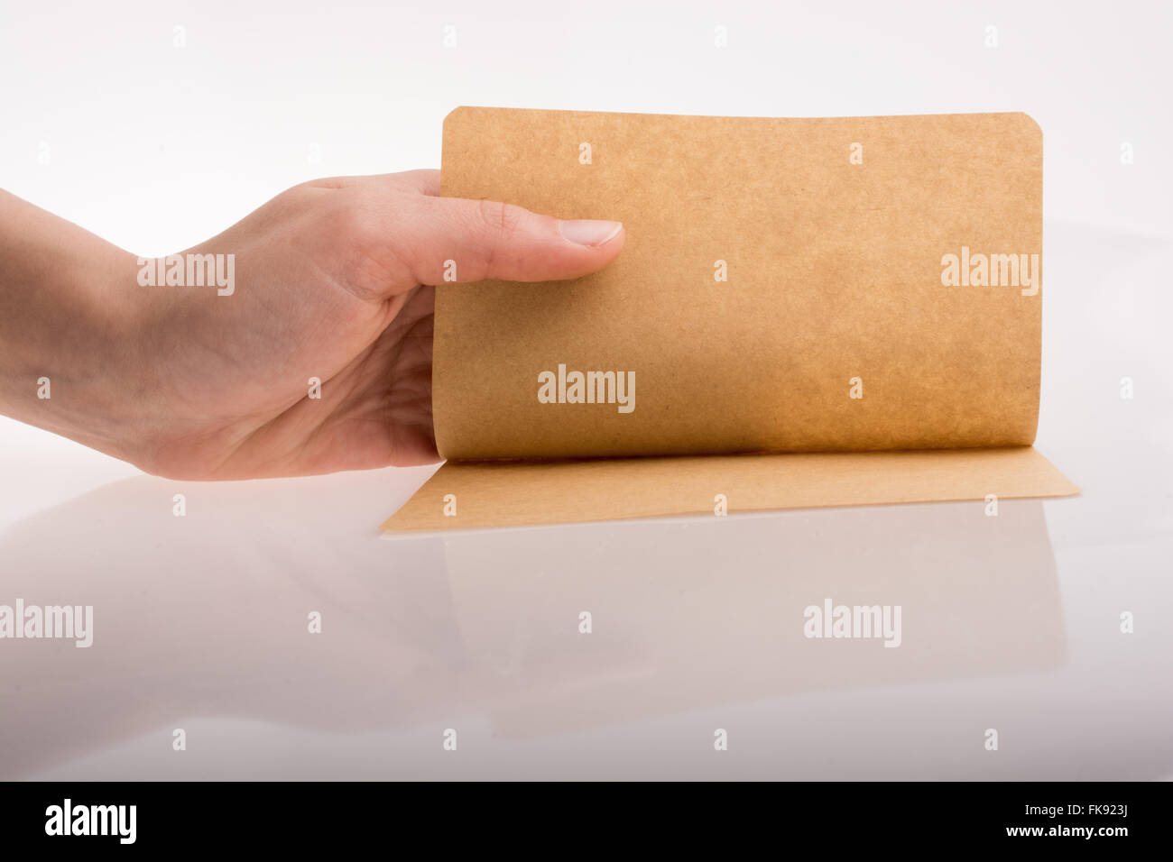 Hand holding a sheet of paper on a white background Stock Photo - Alamy
