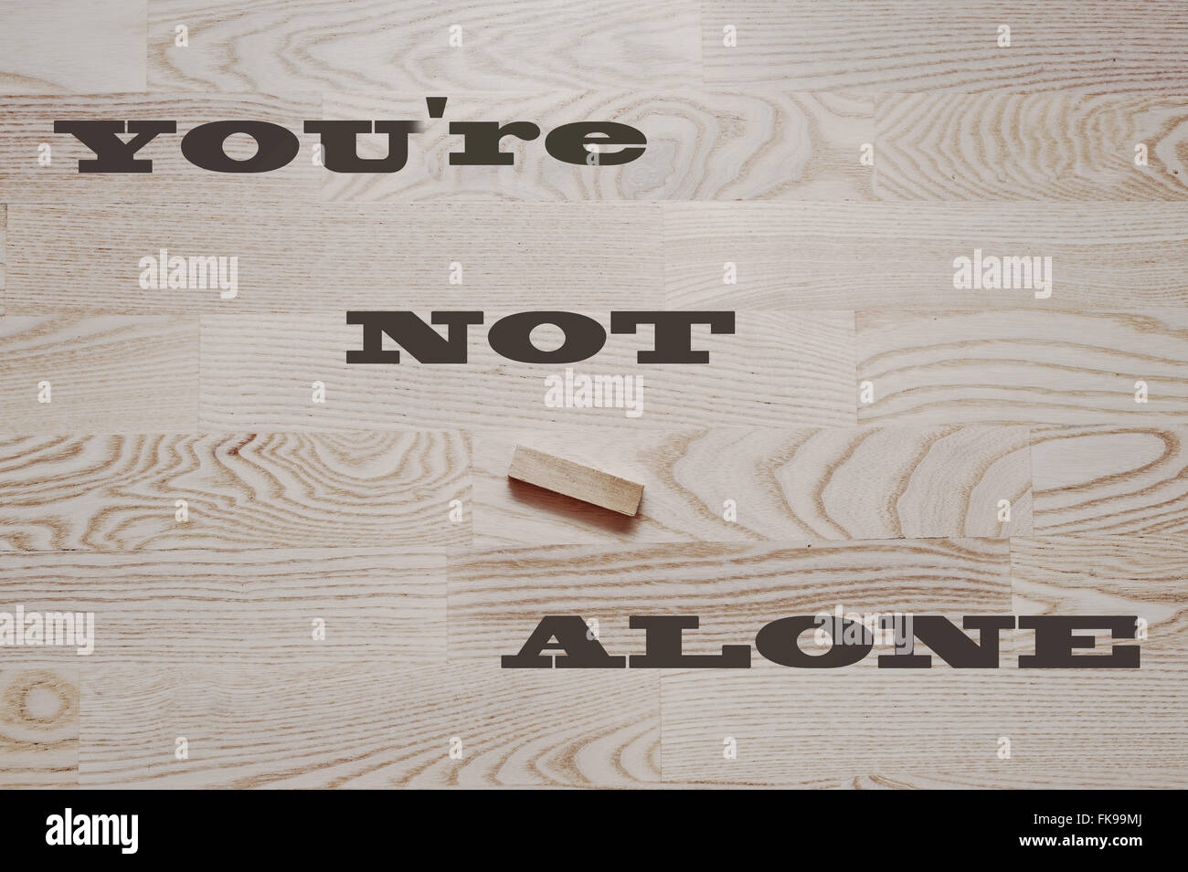 Your not alone word on wooden background Stock Photo - Alamy