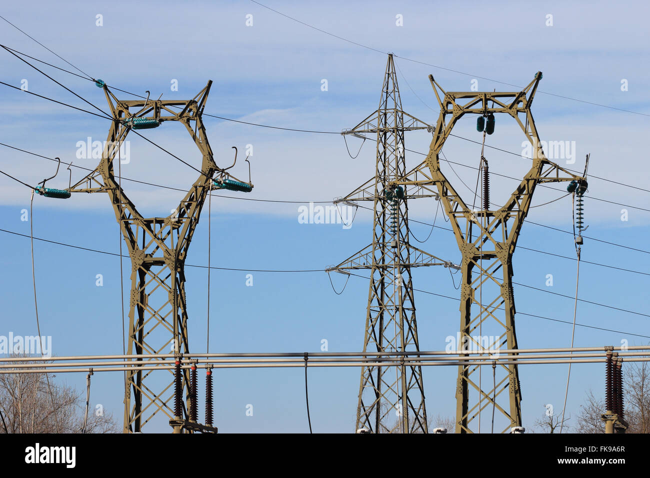 Electric pillars over blue sky close to a Power plant Stock Photo - Alamy