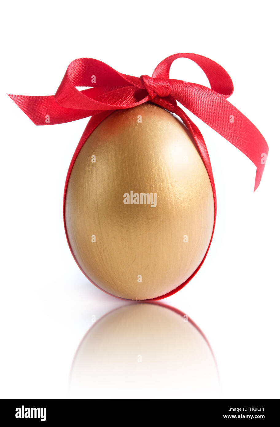 Gold egg tied with red ribbon over a white background Stock Photo - Alamy