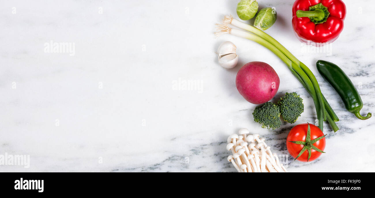 Overhead view of various whole vegetables and fruits, on right side of ...