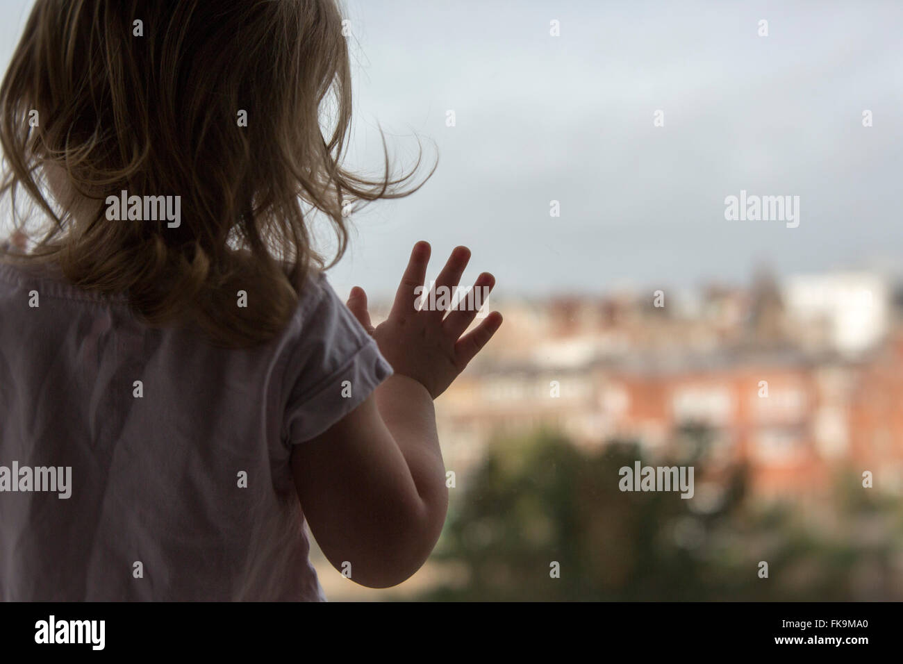 Toddler looking out of hotel room window with airplanes flying past ...