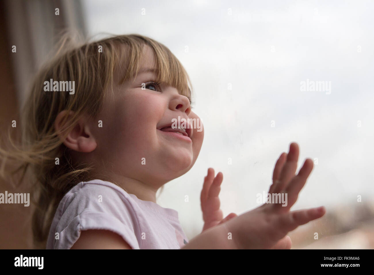 Toddler looking out of hotel room window with airplanes flying past ...