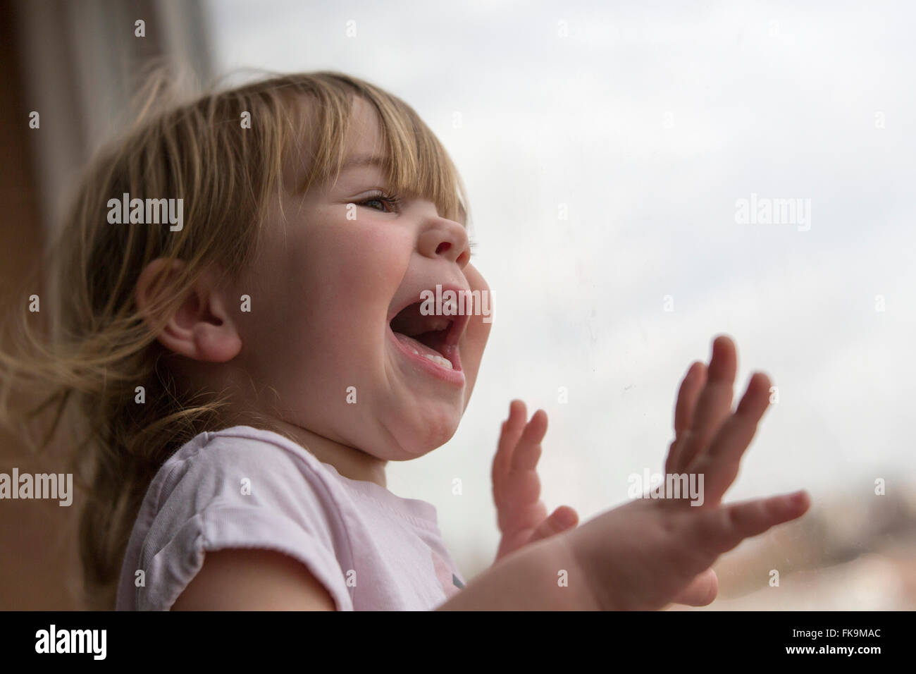 Toddler looking out of hotel room window with airplanes flying past ...