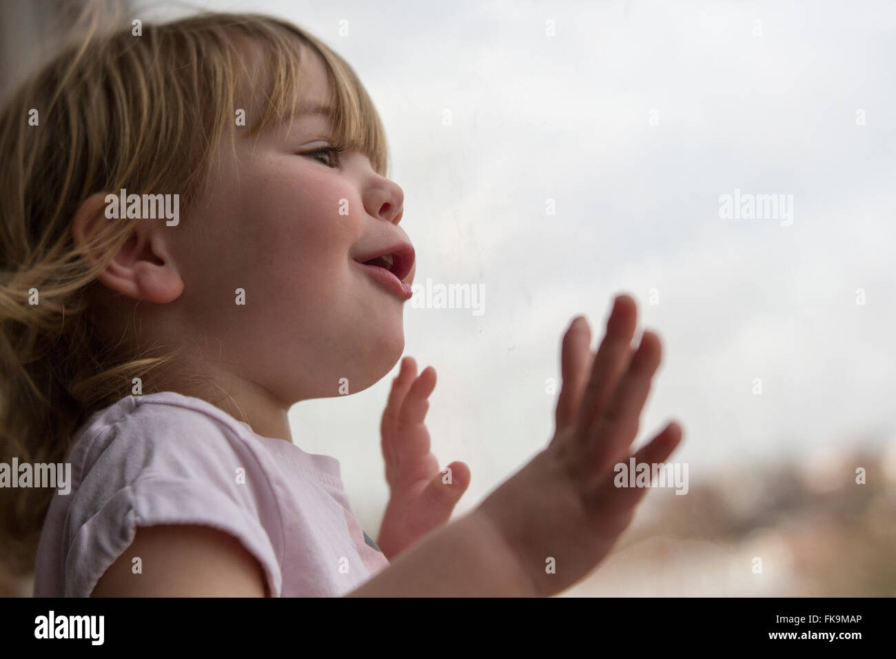 Toddler looking out of hotel room window with airplanes flying past ...