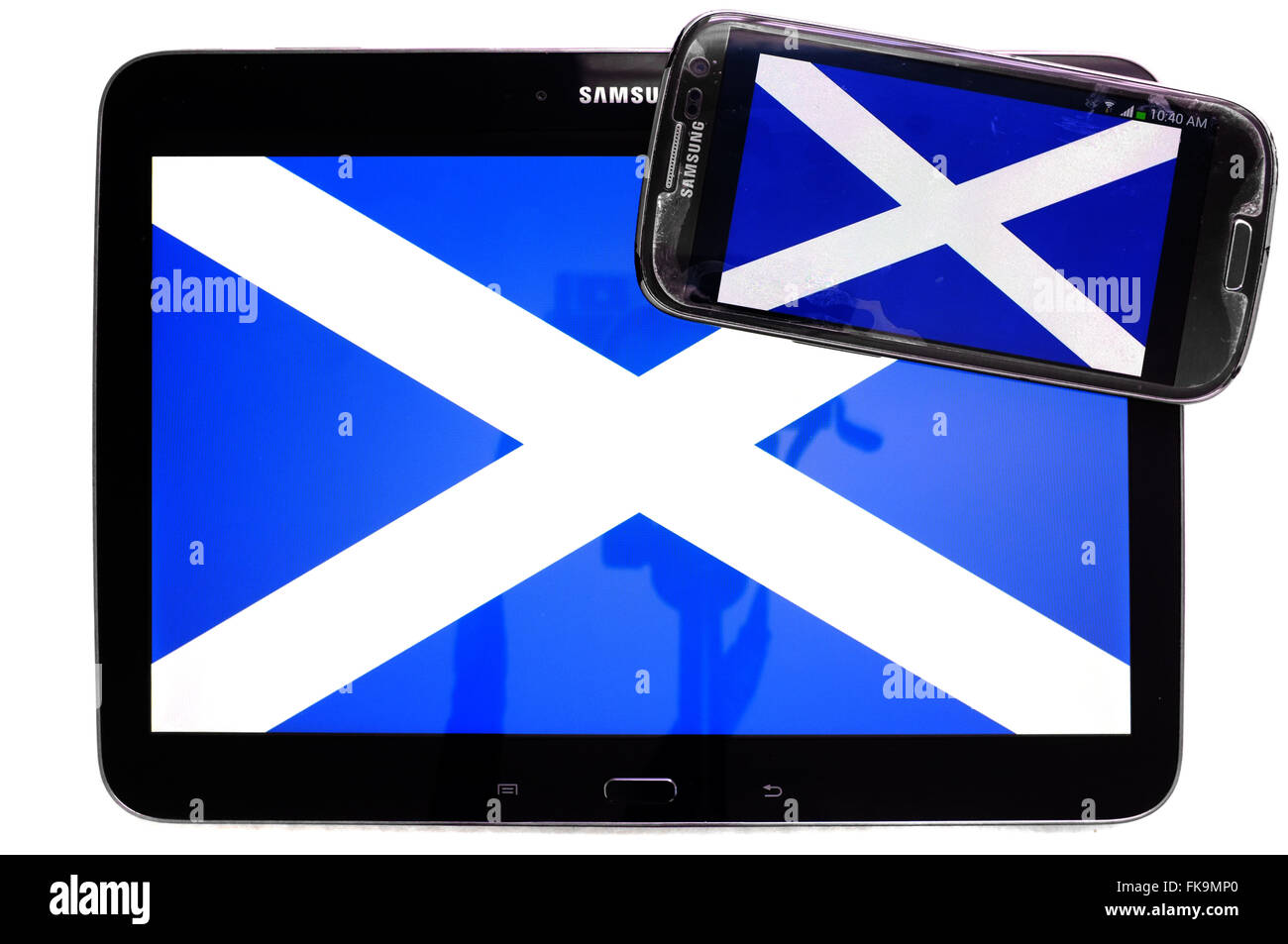A tablet and a smartphone with the Scottish flags on them against a ...