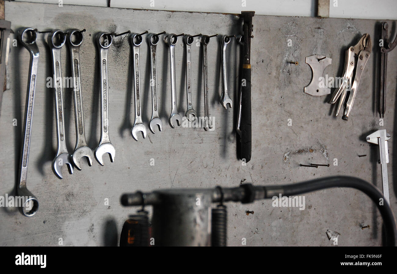 mechanic tools hanging on a organized woodenl board at a vehicle ...