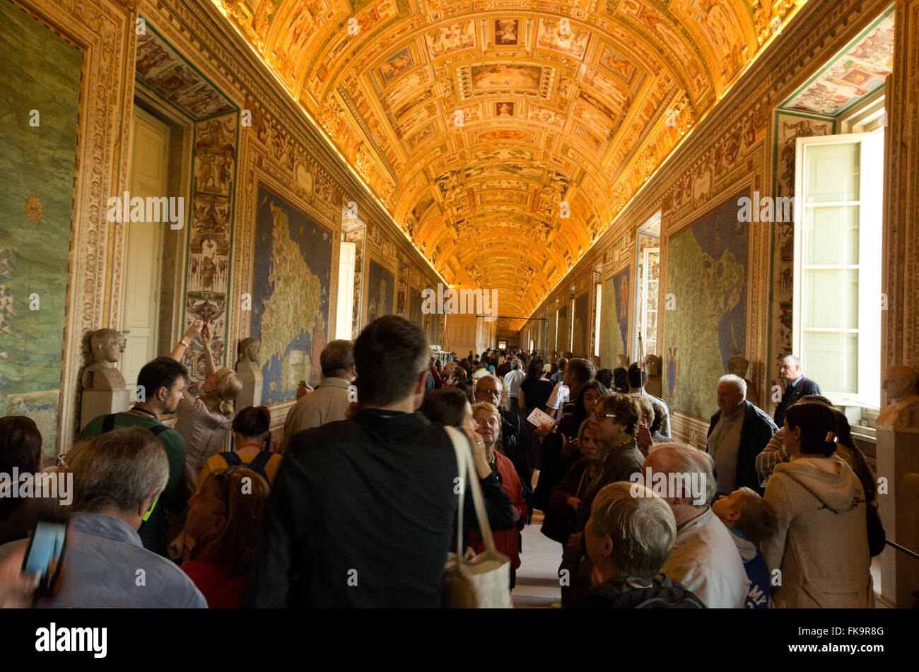 Large crowds of tourist traveling through the long hall with gold ...
