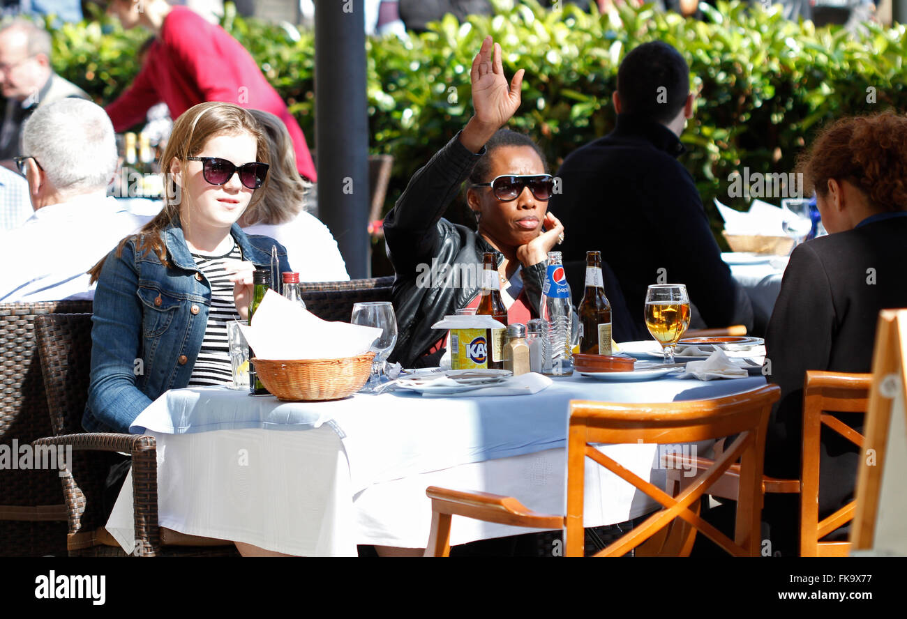Girls callin waiter in one restaurant Stock Photo - Alamy