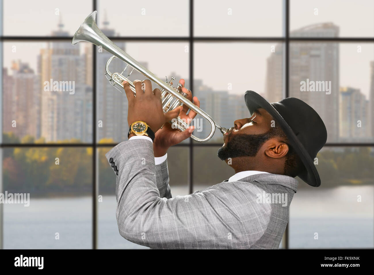 Black trumpeter performing at daytime. Afro trumpeter on urban ...