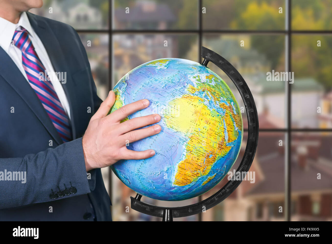 Businessman with globe beside window Stock Photo - Alamy