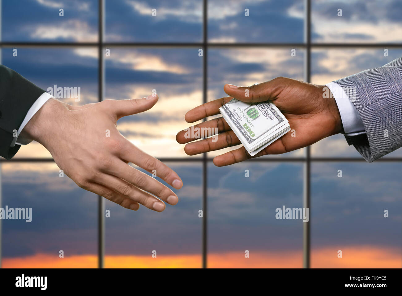 Businessman handing money near window Stock Photo - Alamy