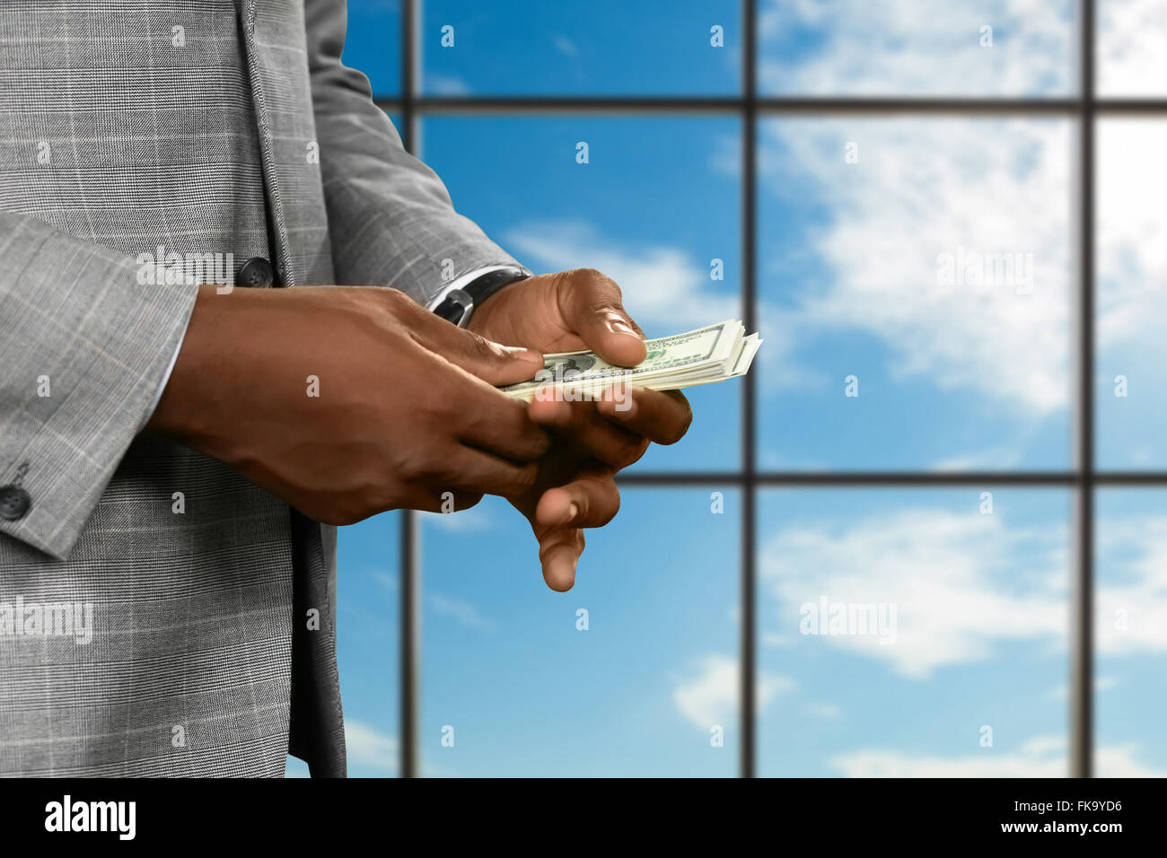 Businessman counts money near window Stock Photo - Alamy