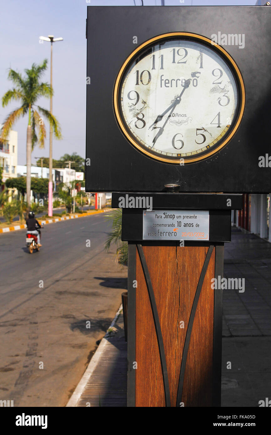 Totem advertising with clock on sidewalk Stock Photo - Alamy