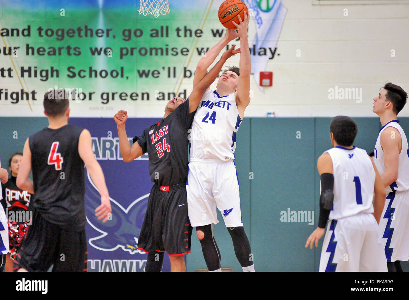 Players battling for a rebound during a high school basketball game ...