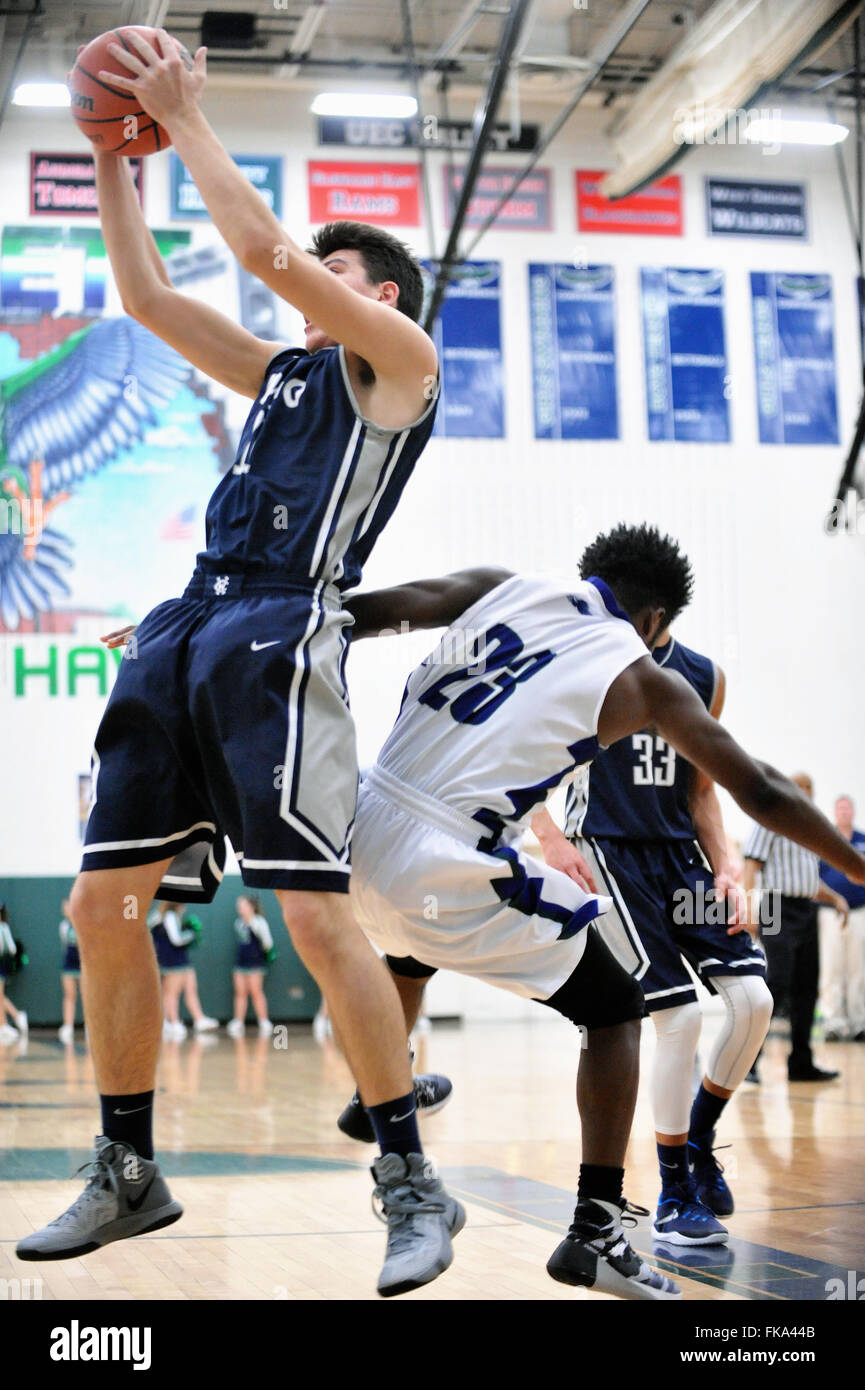 Player pulling down a rebound during as an opponent gets entirely ...