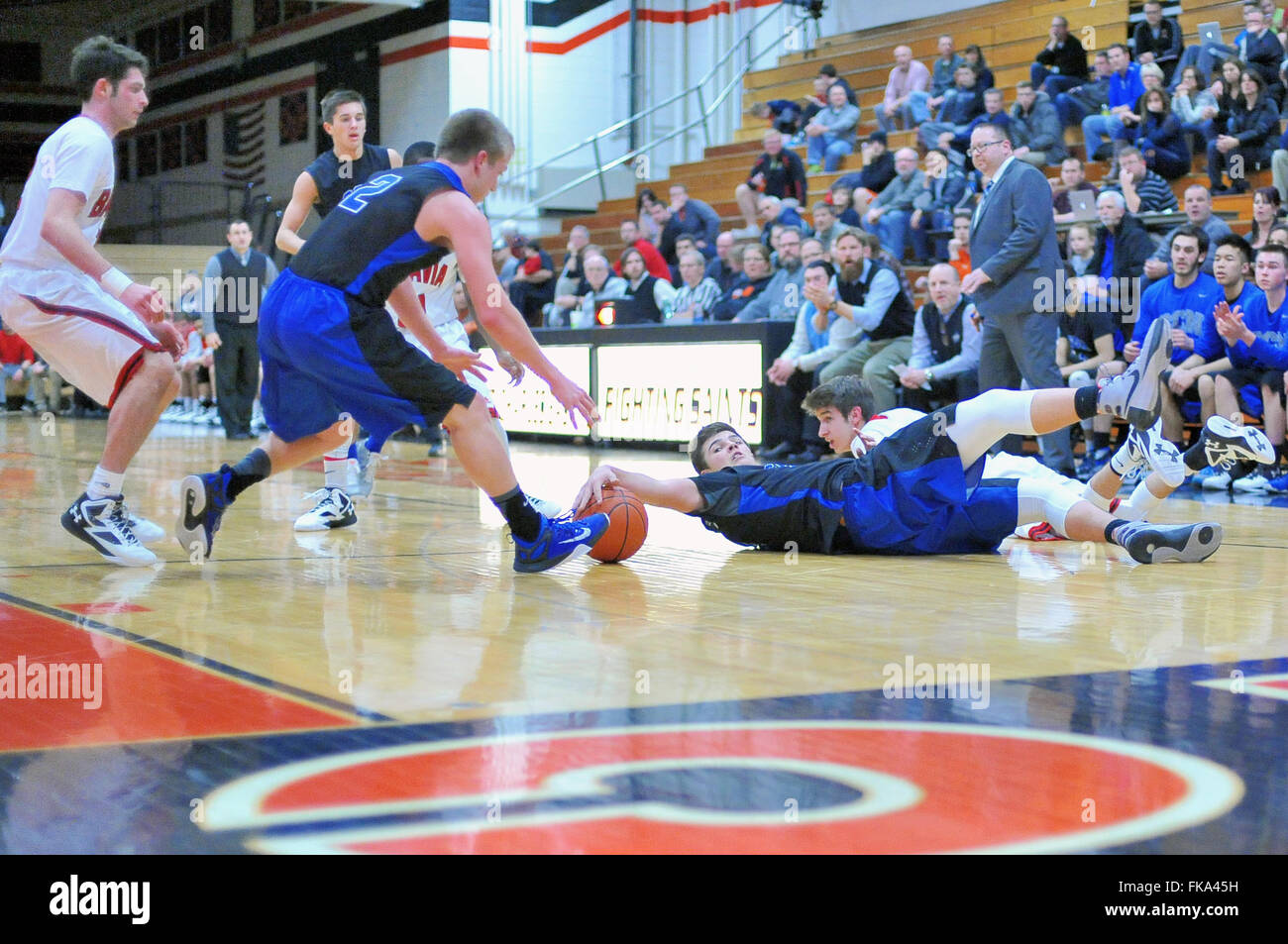Players scramble on the floor for possession of a loose ball during a ...