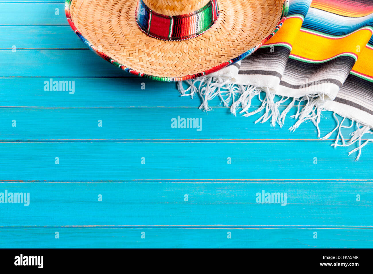 Mexican sombrero and traditional serape blanket laid on an old blue ...