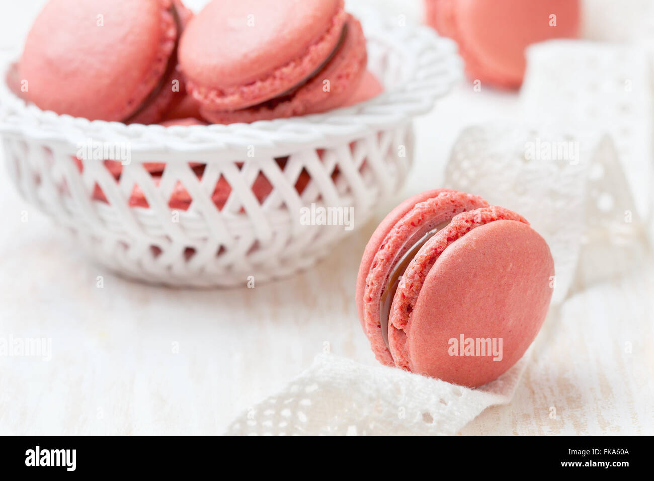 several pink macaroon on a white wooden background (light Stock Photo ...