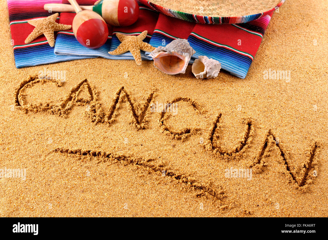 The word Cancun written in sand on a Mexican beach, with sombrero ...