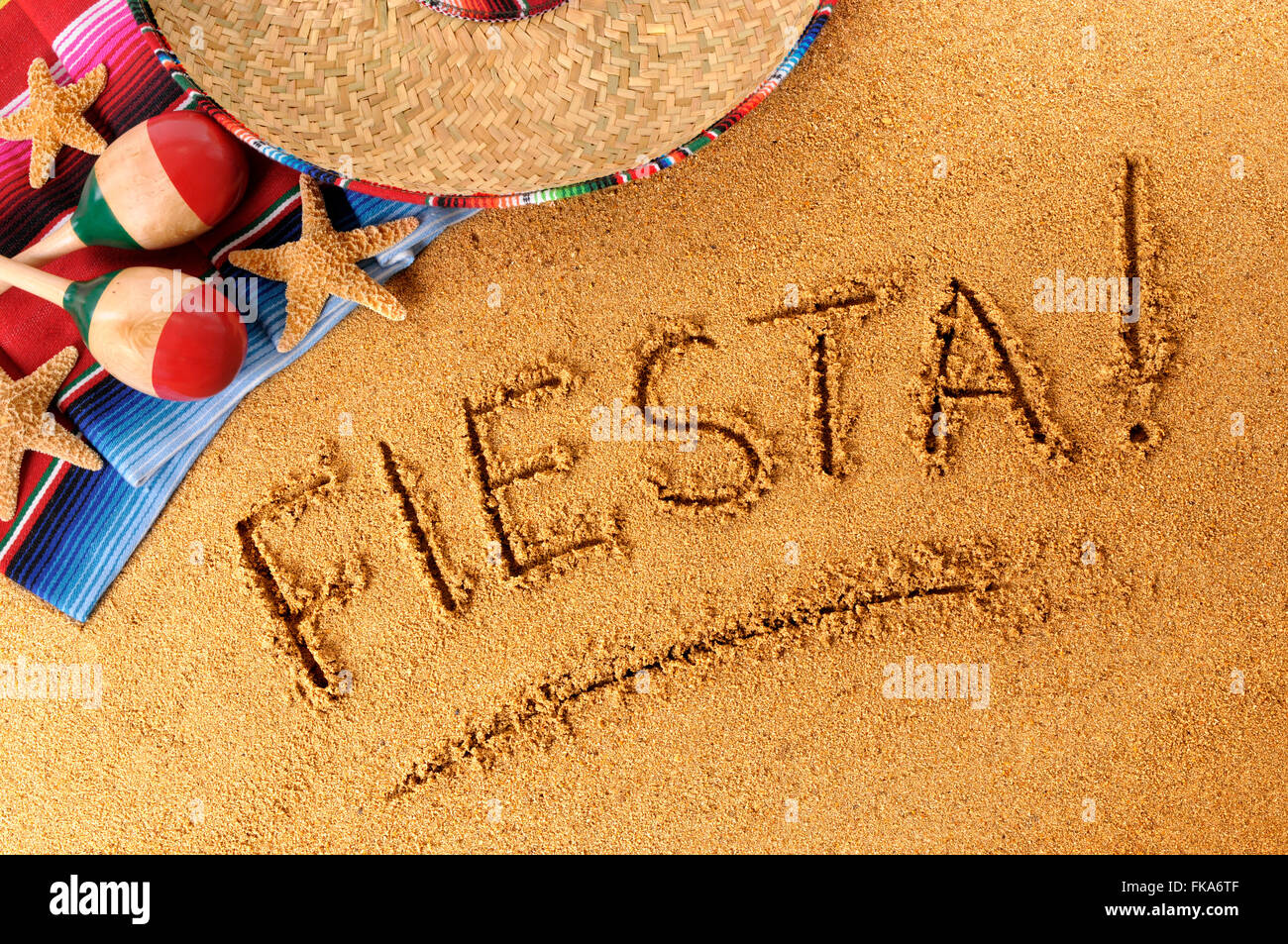 The word Fiesta written in sand on a Mexican beach, with sombrero ...