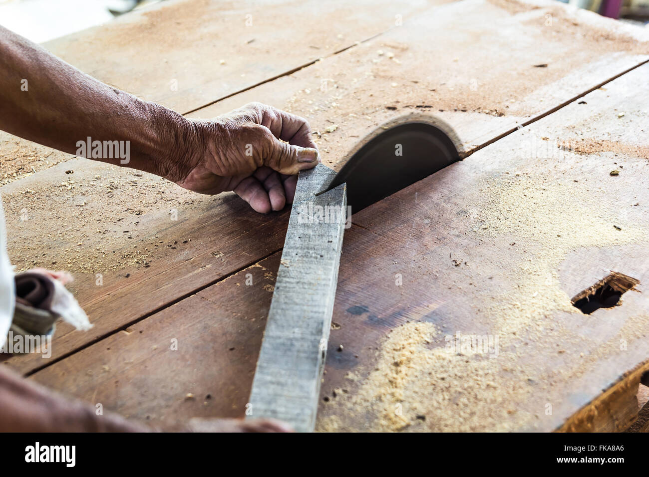 Close up shot hand of man worker with Circular saw cutting wooden plank ...