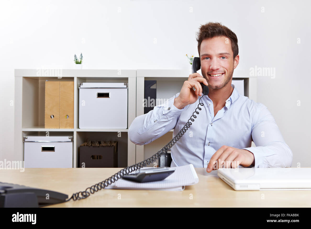 Happy business man making a phone call in office Stock Photo - Alamy