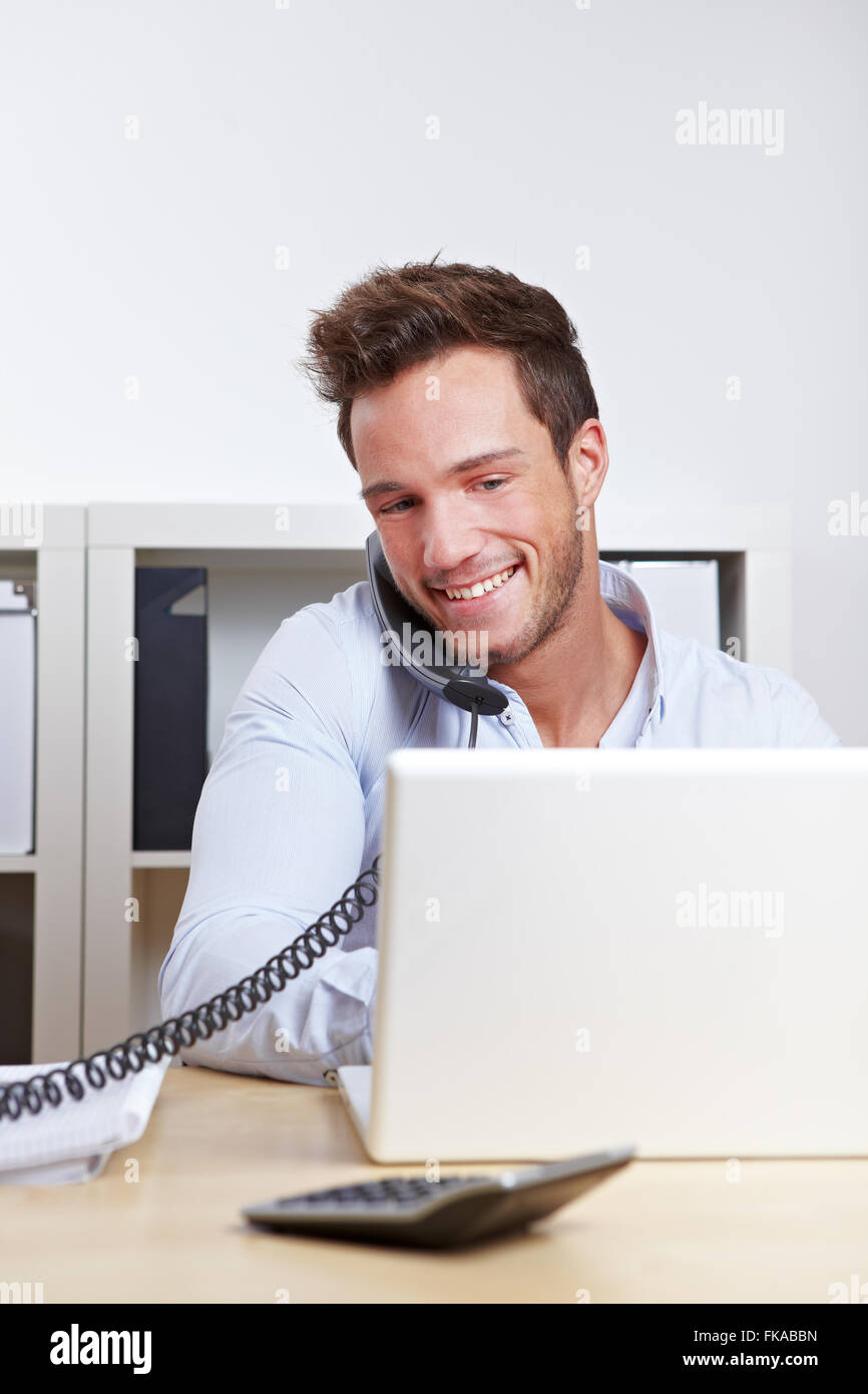 Happy young business in office making a phone call Stock Photo - Alamy