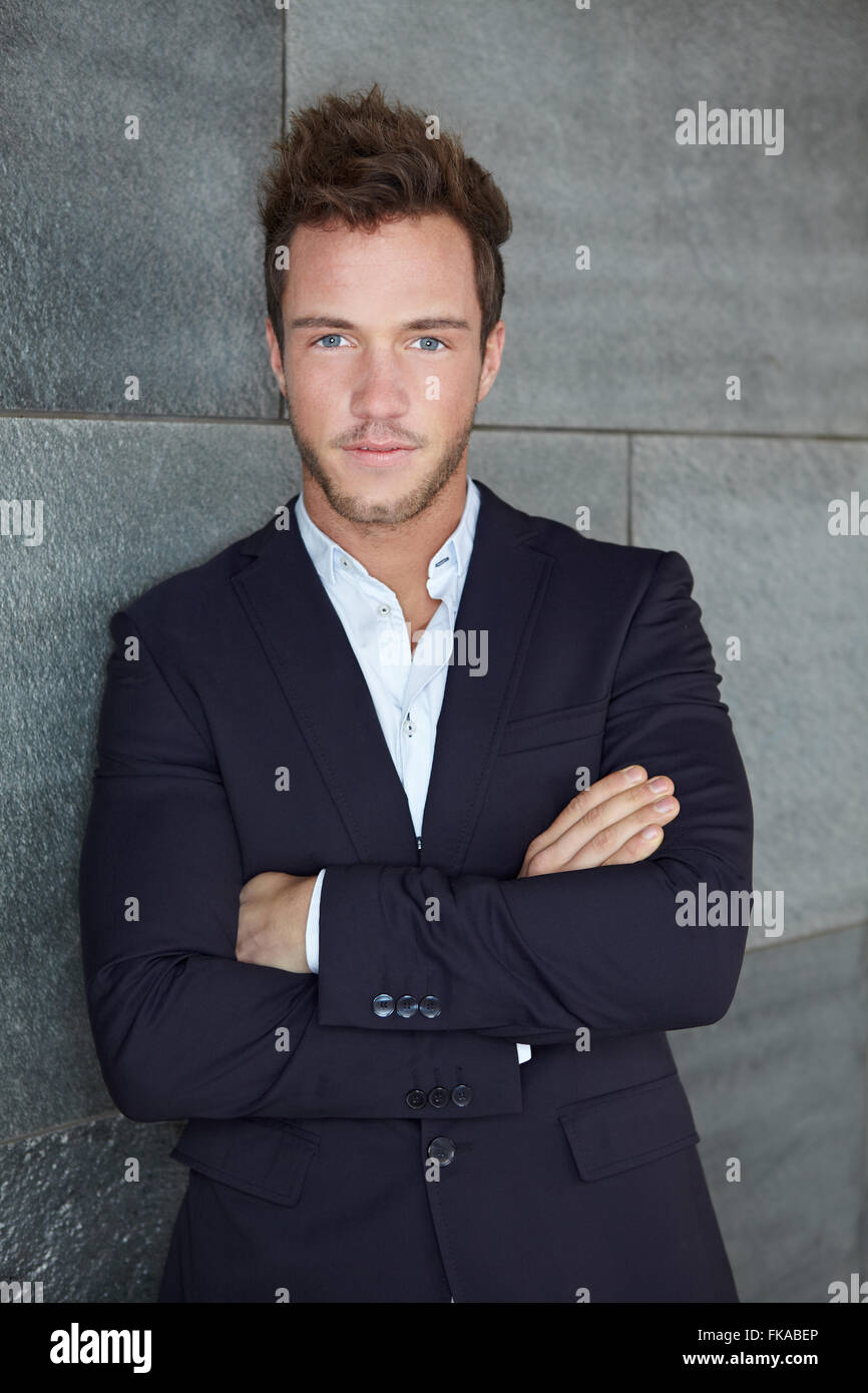 Cool business man leaning on urban wall outdoors Stock Photo - Alamy