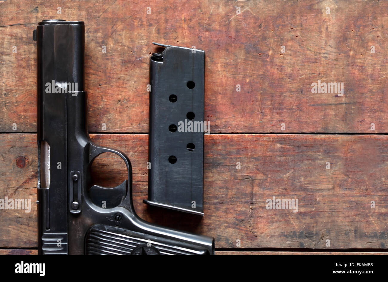 Still life with old black handgun near holder on nice wooden background ...