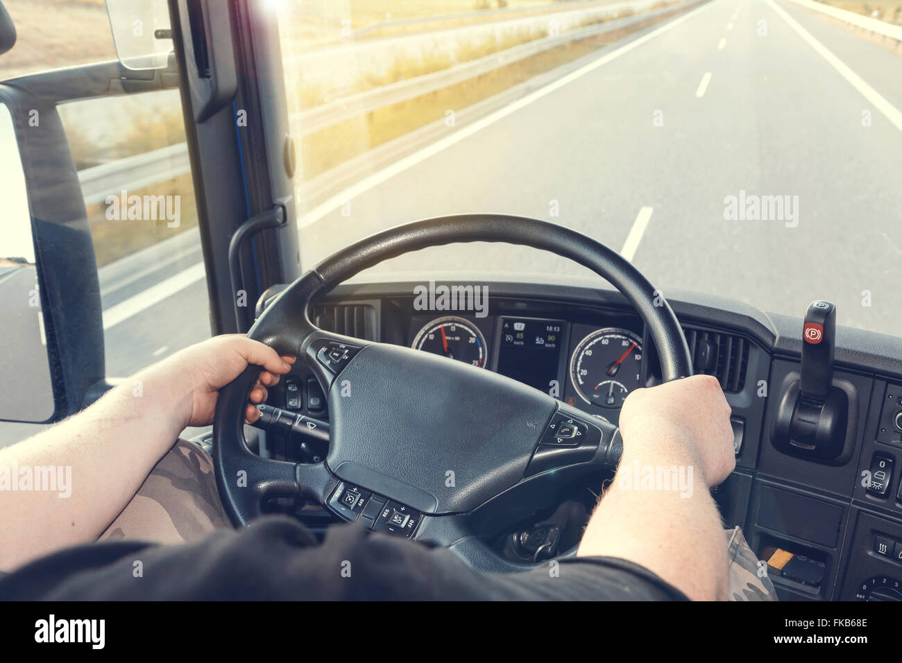 View on the dashboard of the truck driving. The driver is holding the ...