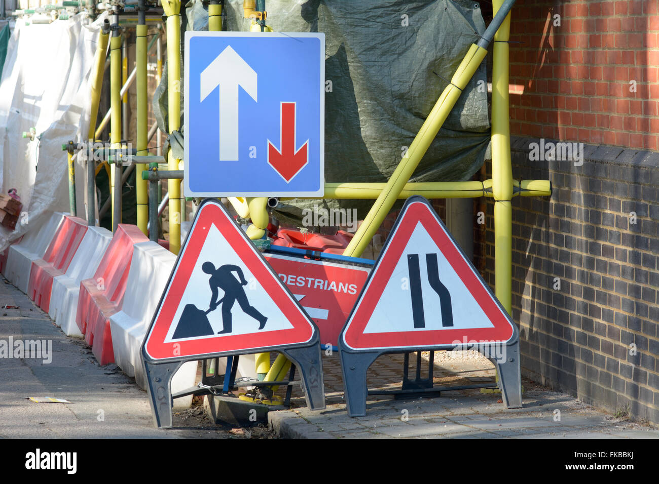 Road traffic signs on pavement next to scaffolding - warning drivers ...