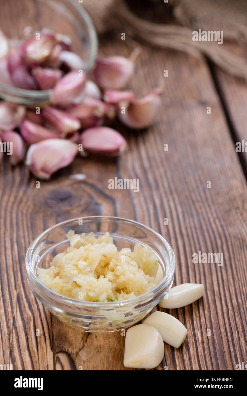 Portion of Crushed Garlic (close-up shot) on wooden background Stock ...