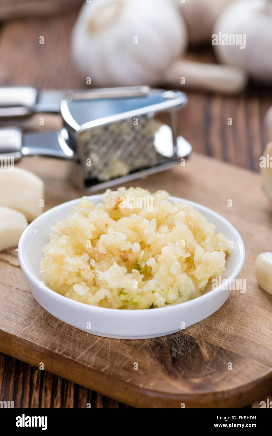 Portion of Crushed Garlic (close-up shot) on wooden background Stock ...