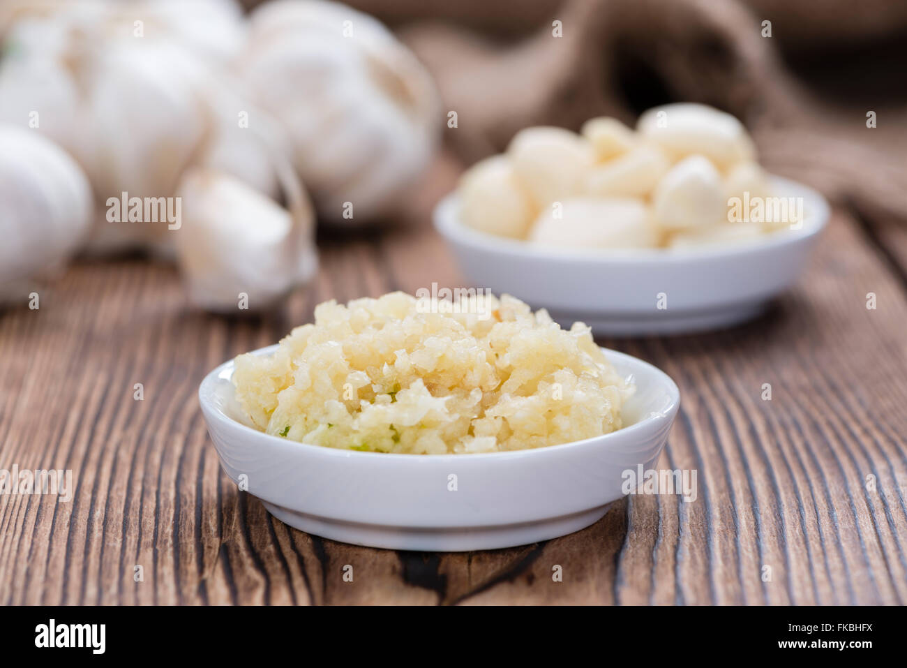 Portion of Crushed Garlic (close-up shot) on wooden background Stock ...