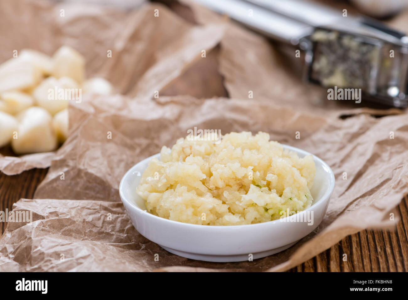 Portion of Crushed Garlic (close-up shot) on wooden background Stock ...