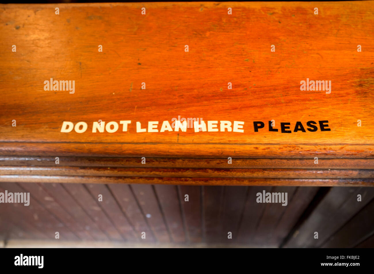 Do not lean here please - sign on a pub bar counter Stock Photo - Alamy