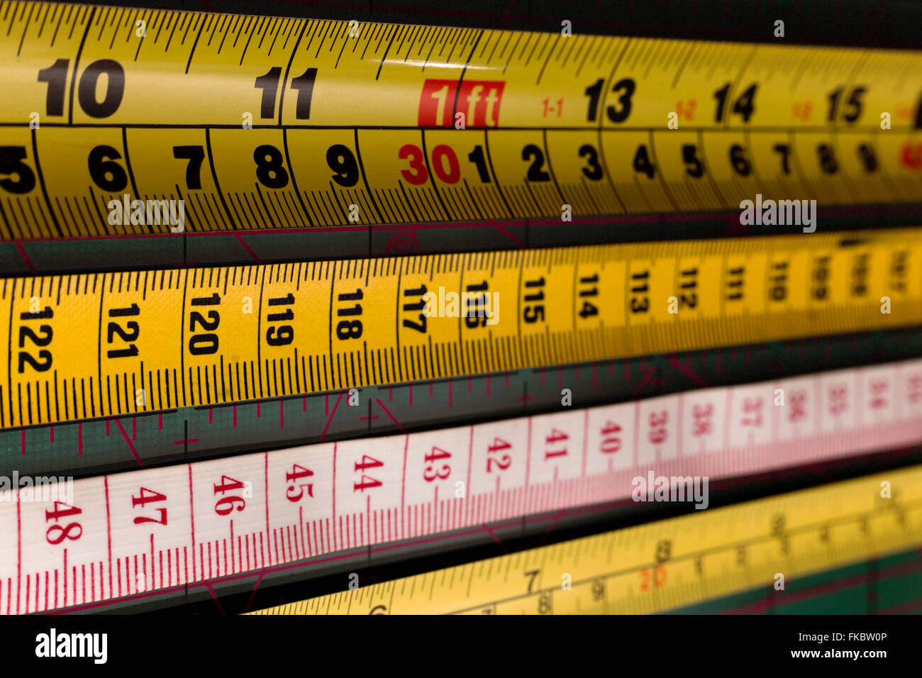 Four tape measures slightly tilted Stock Photo - Alamy