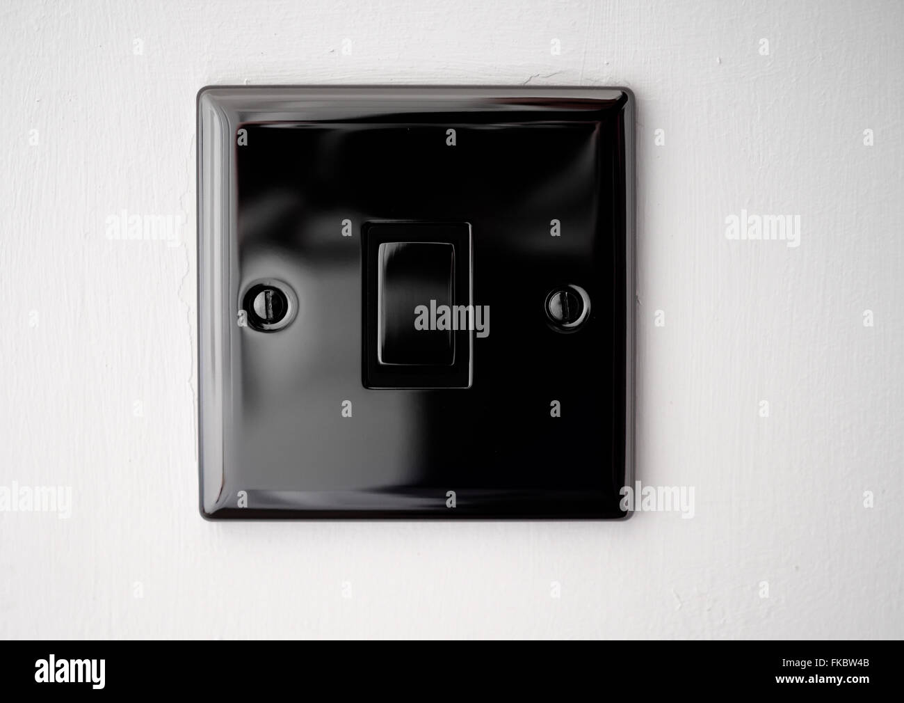 Black house hold light switch on a white wall Stock Photo - Alamy