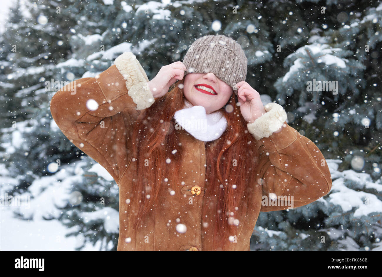Winter woman blinded snow on head, fir trees background Stock Photo - Alamy