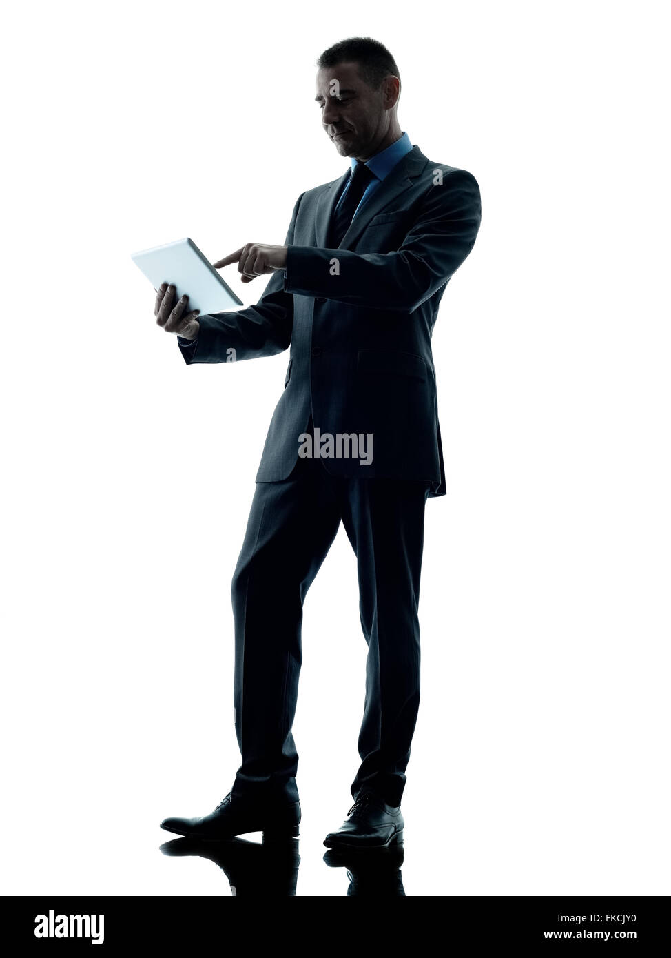one caucasian business man standing using digital tablet silhouette isolated on white background ...