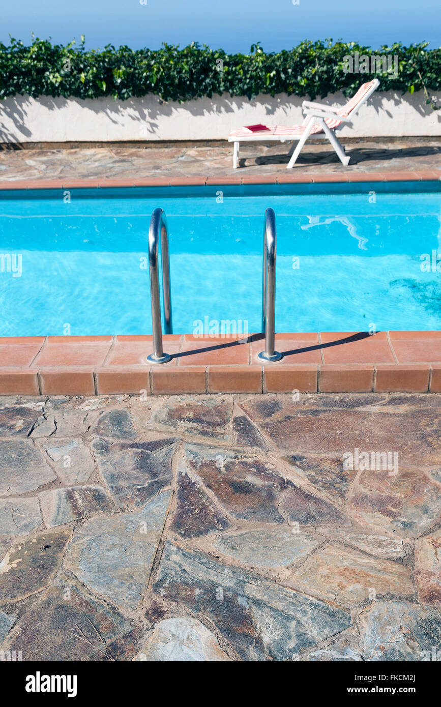 empty swimming pool with ivy on wall with chair and blue sky Stock ...