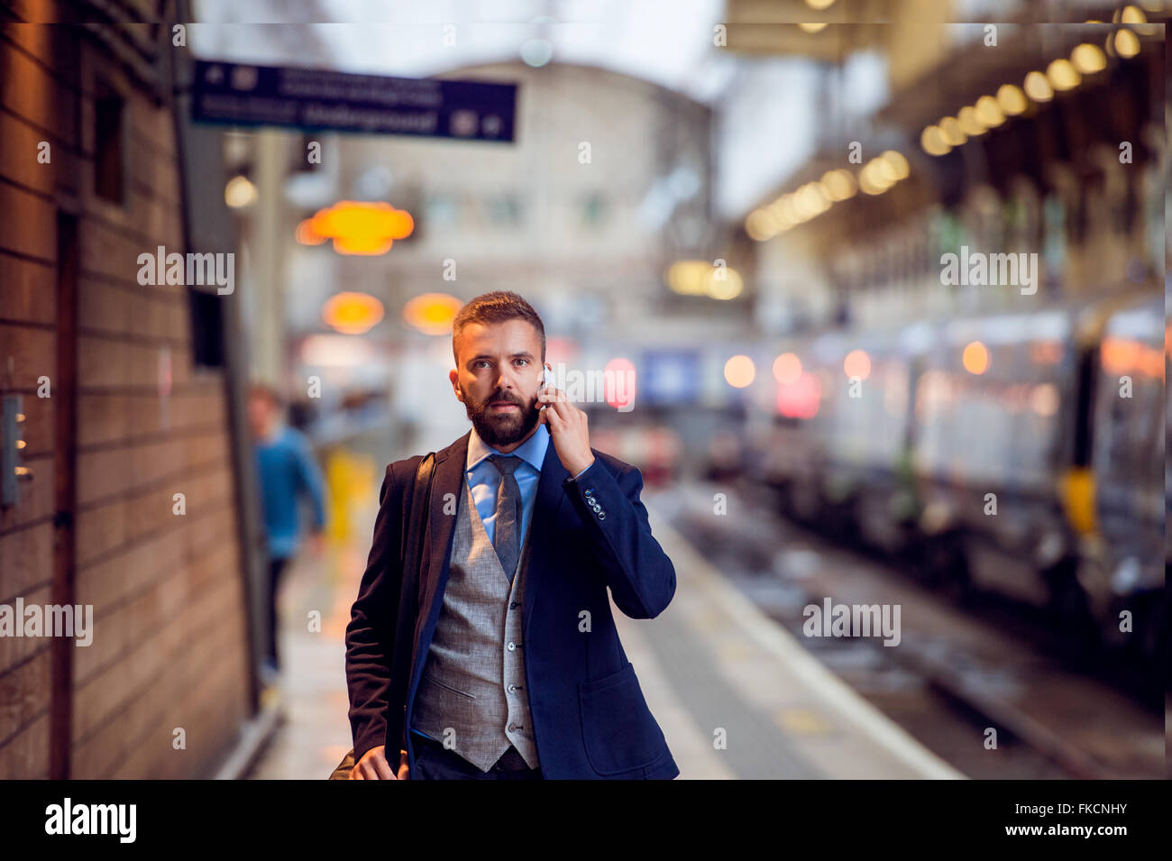 Businessman with smartphone, making a phone call, train platform Stock ...