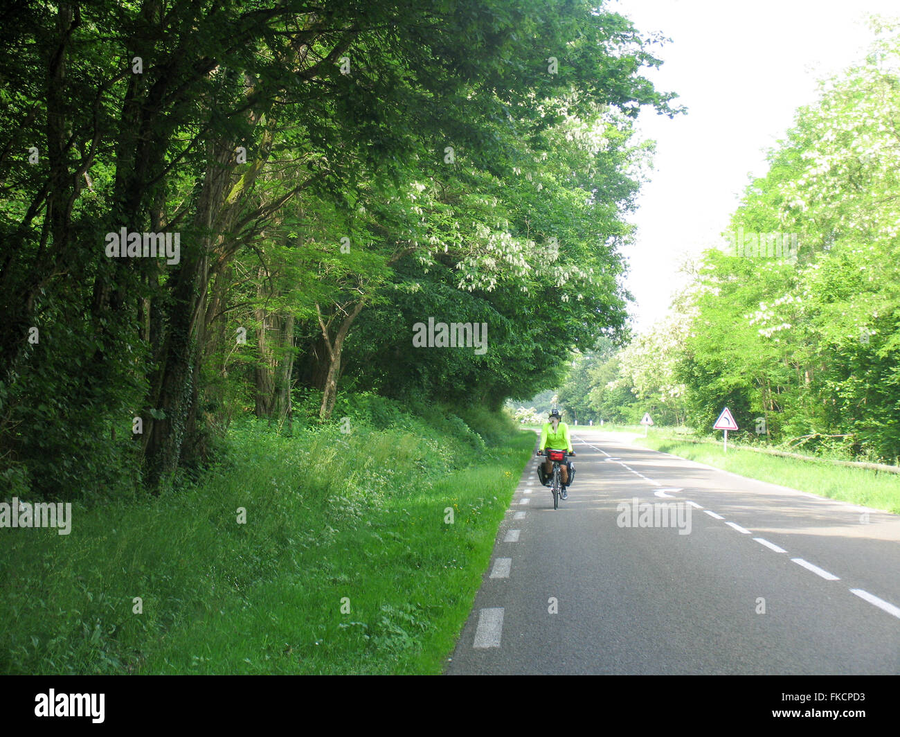 A touring cyclist riding on a road in the French countryside Stock ...