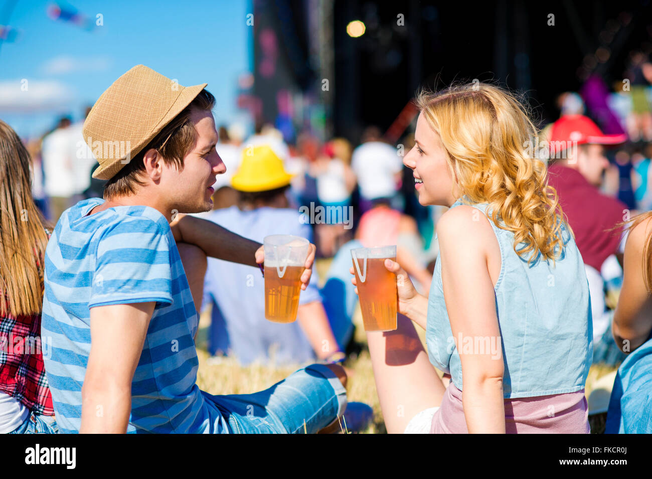 Young couple with beer at summer music festival Stock Photo - Alamy